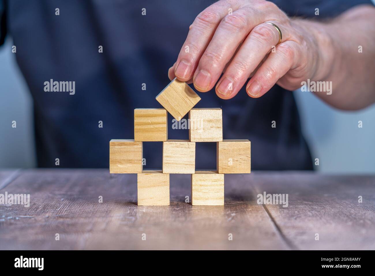 Balancing building blocks pointing upwards to the roof Stock Photo - Alamy