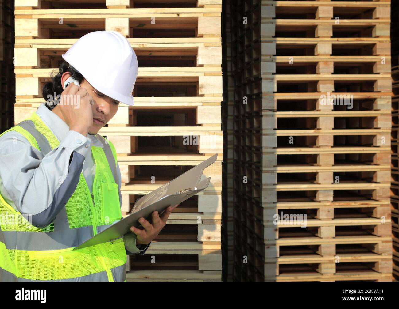 warehouse worker calling beside stacking pallet Stock Photo - Alamy