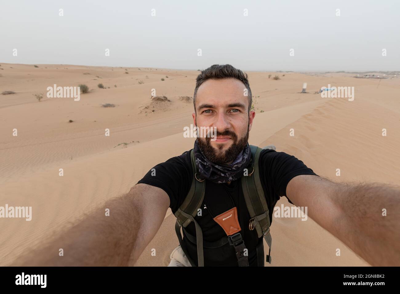 A young man takes a selfie in the desert near Dubai, United Arab ...