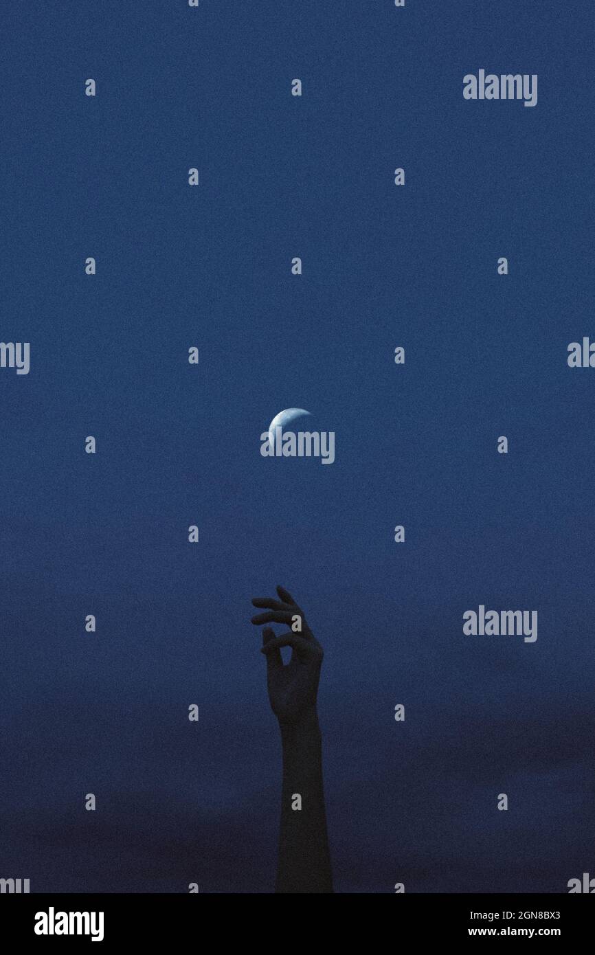 Hand reaching to the crescent of the moon on a night sky Stock Photo ...