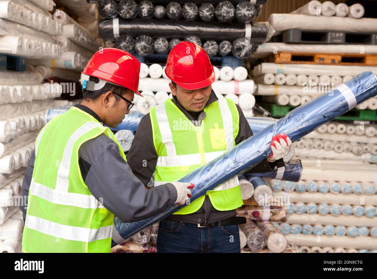 Textile factory workers checking fabric in werehouse Stock Photo - Alamy