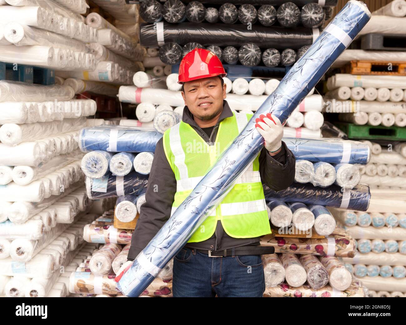 Textile factory worker carrying raw material fabric Stock Photo - Alamy