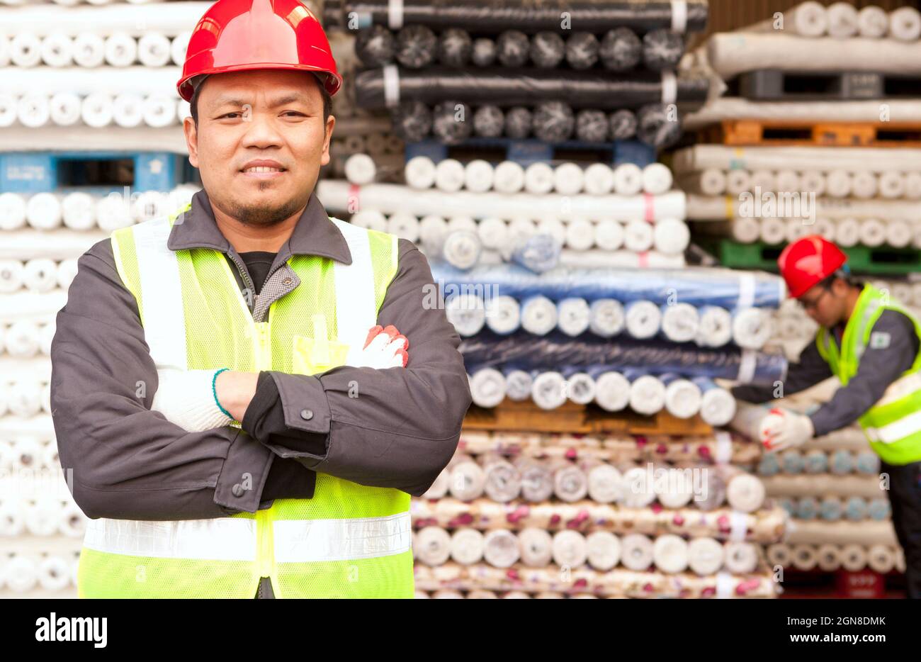 Textile factory worker standing in werehouse fabrics Stock Photo - Alamy