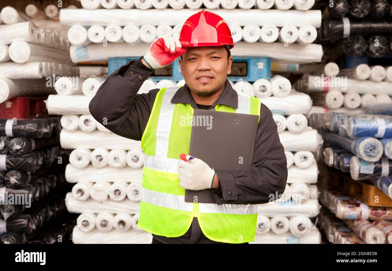 Textile factory labor standing in werehouse fabrics Stock Photo - Alamy