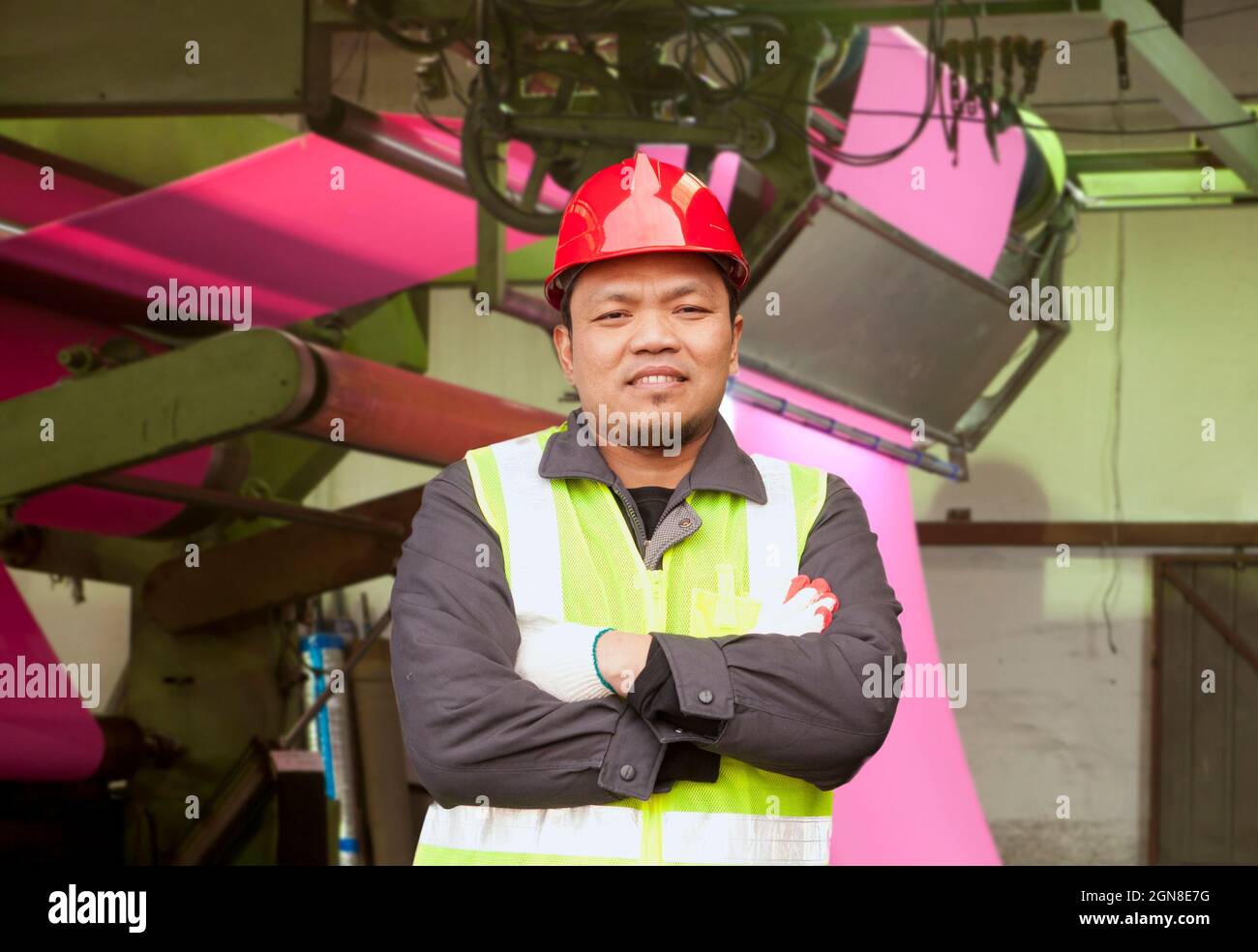 Textile factory engineer standing beside machine Stock Photo - Alamy