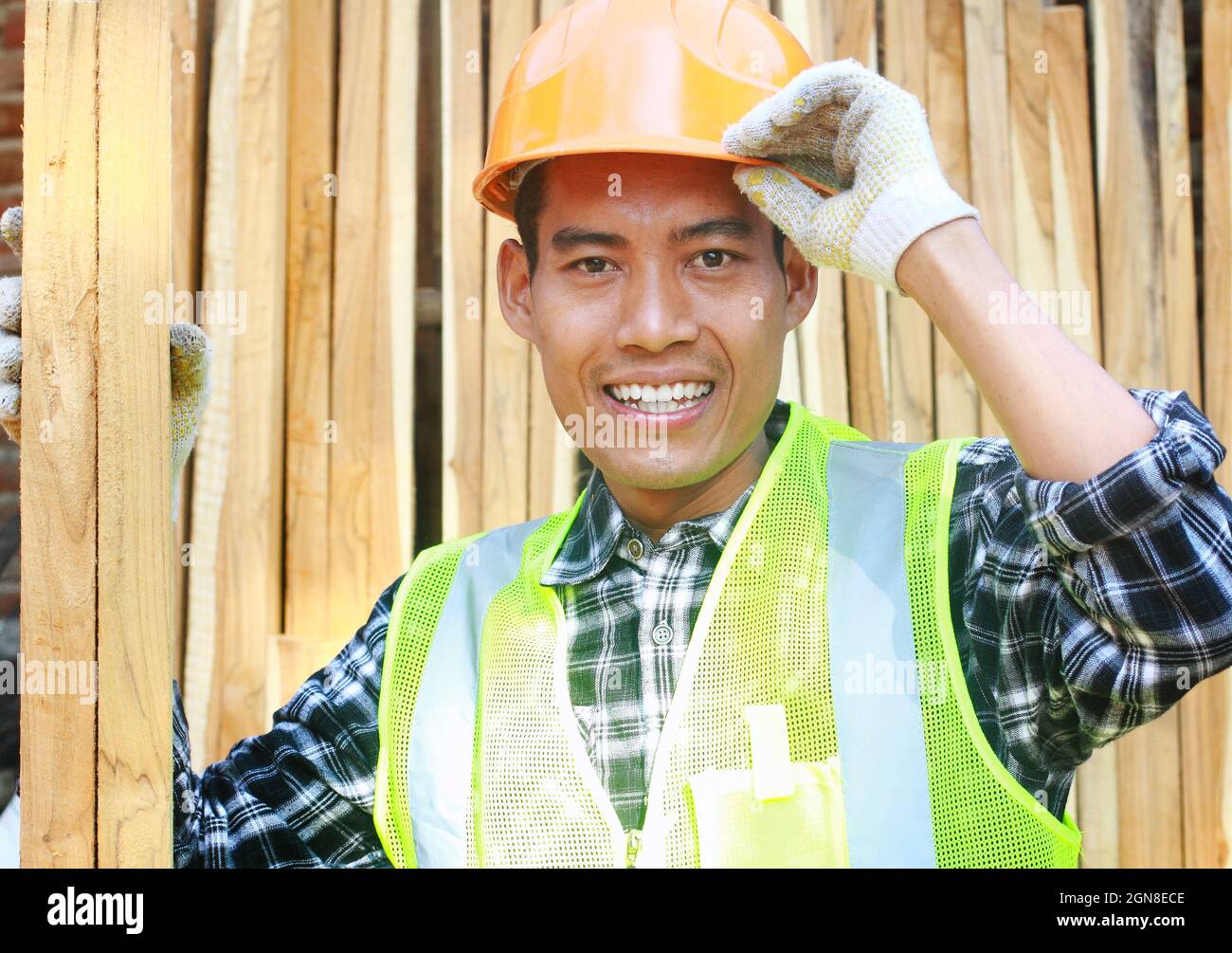 Portrait of a smiling carpenter holding wood look on your camera Stock ...