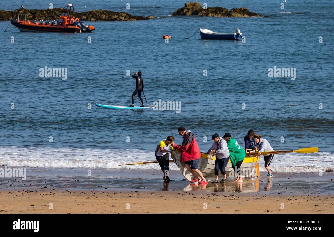Coastal rowing team beach St Ayle's skiff boat at regatta, North Berwick, East Lothian, Scotland ...