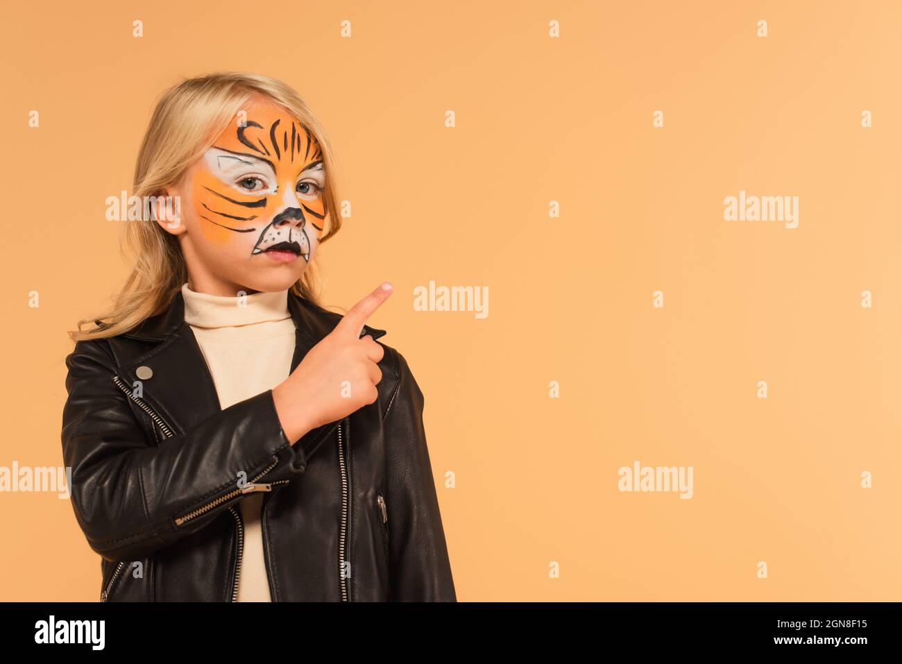 girl in leather jacket and tiger makeup pointing with finger isolated ...