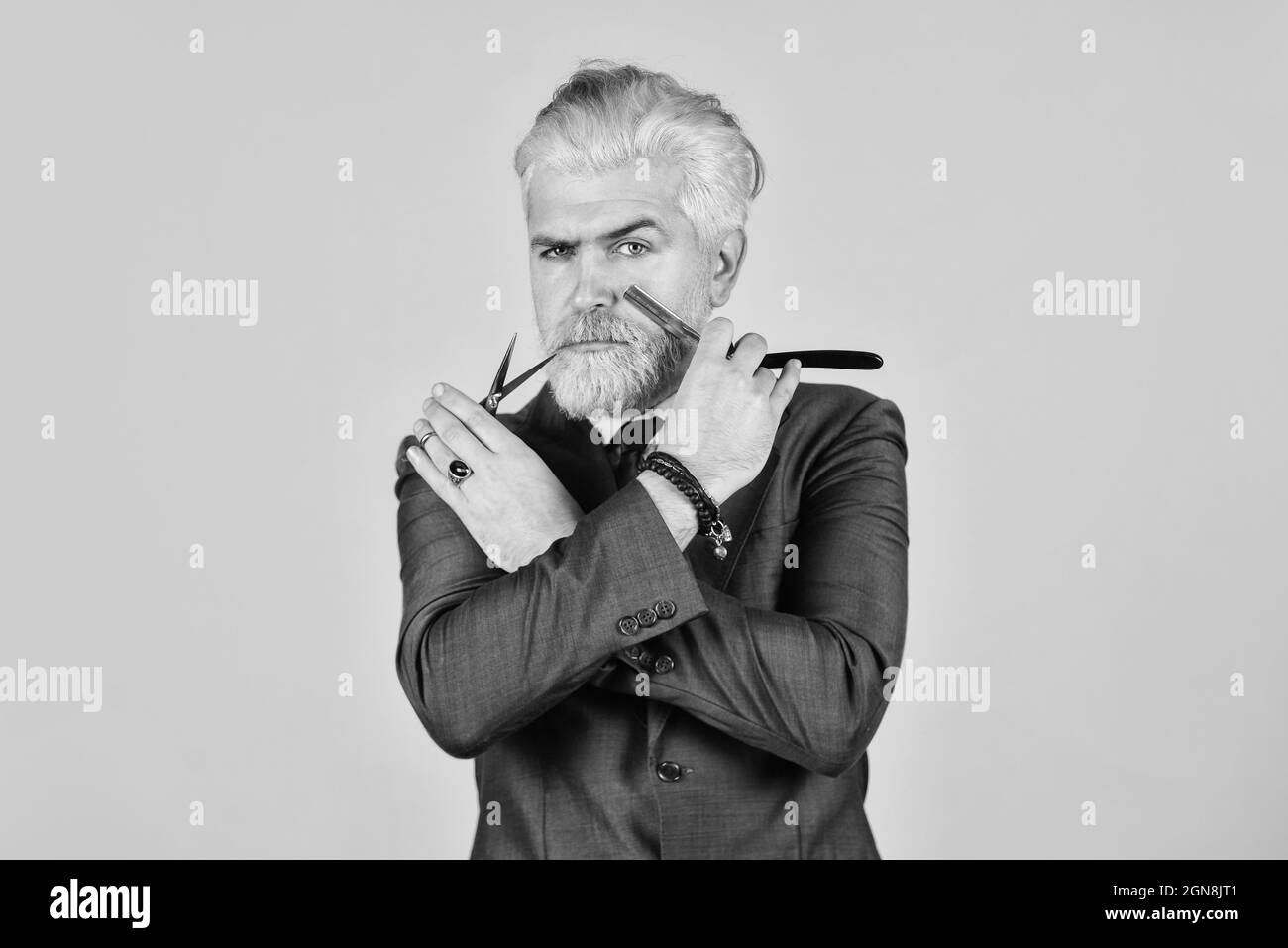 Bleached hair. Personal stylist barber. Bearded man hold razor scissors ...