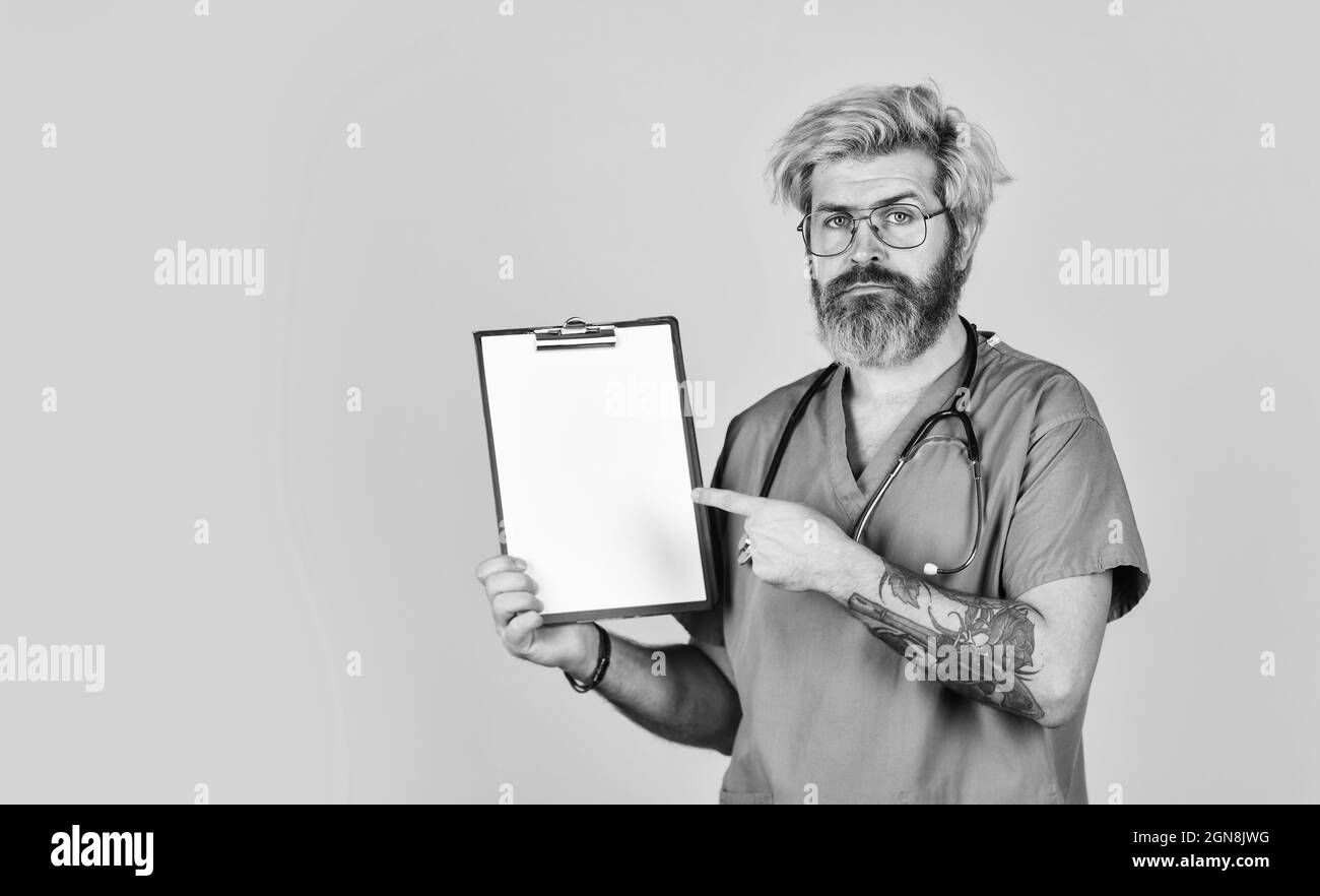 follow my prescription. mature bearded nurse holding clipboard. medical ...