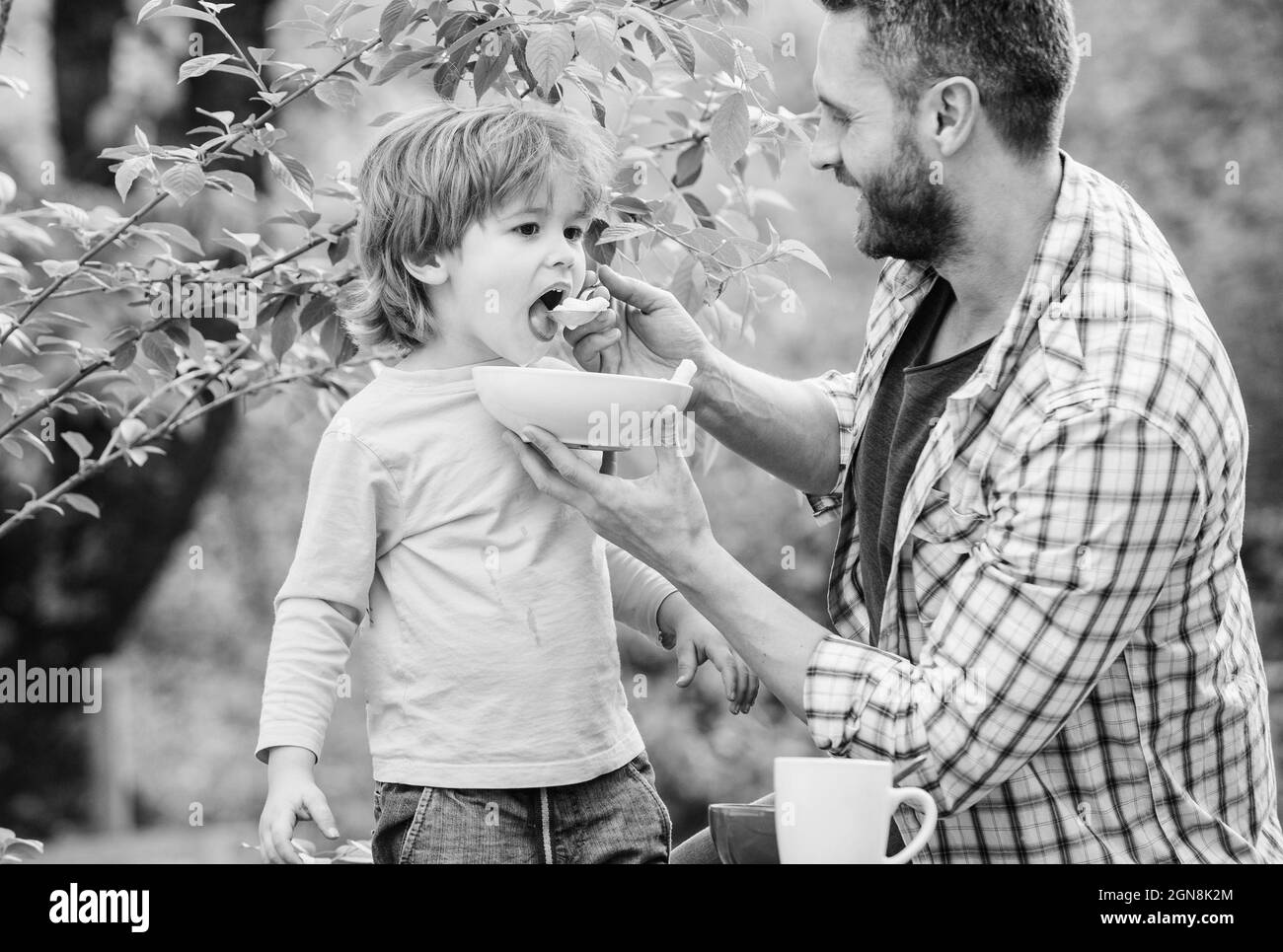 son and father eating outdoor. Morning breakfast. Tasty food. healthy ...