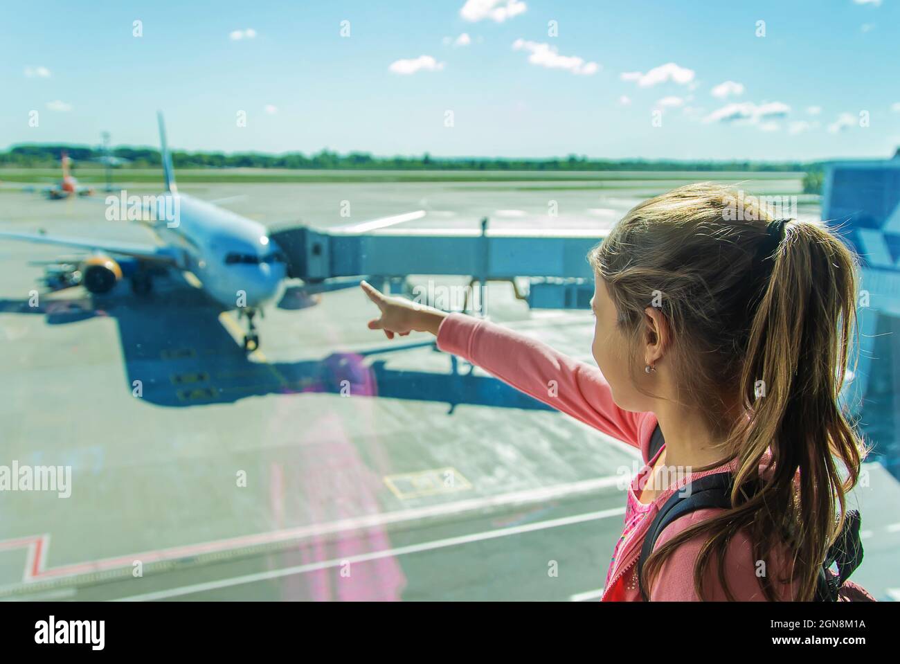 A child at the airport looks at the plane. Selective focus. Kid Stock ...