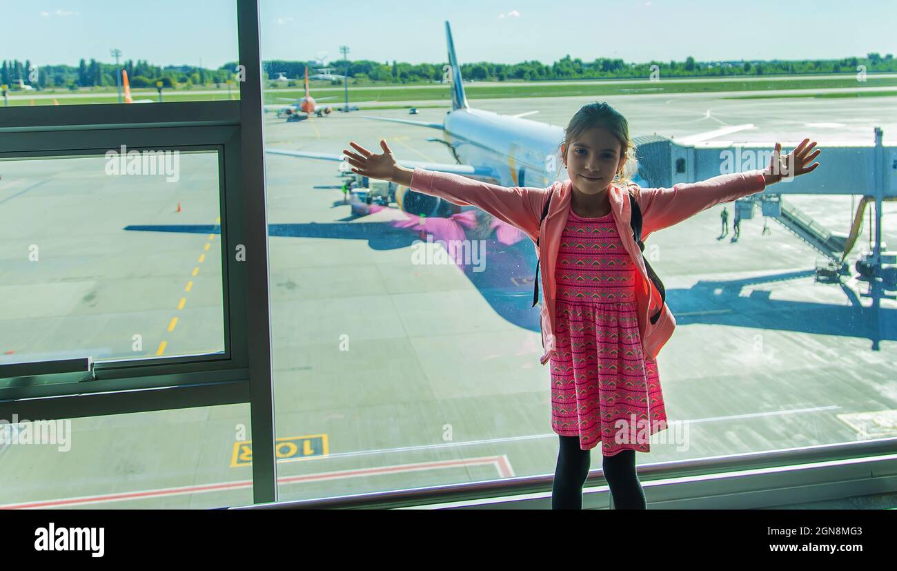 A child at the airport looks at the plane. Selective focus. Kid Stock ...