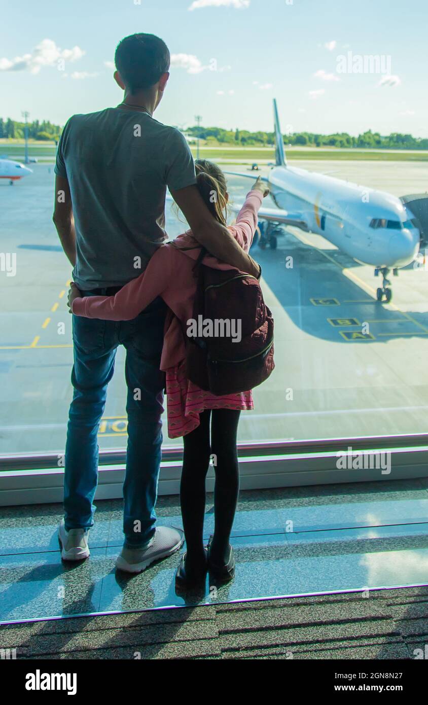A child at the airport looks at the plane. Selective focus. Kid Stock ...