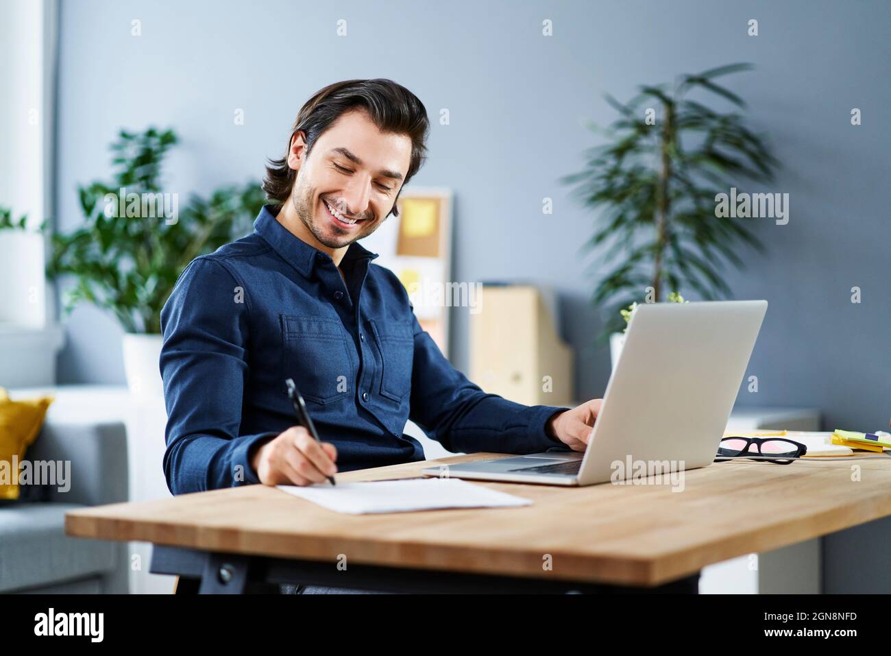 Smiling businessman signing contract at desk Stock Photo - Alamy