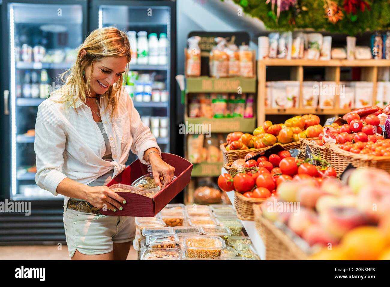 Woman choosing products while shopping at organic store Stock Photo - Alamy