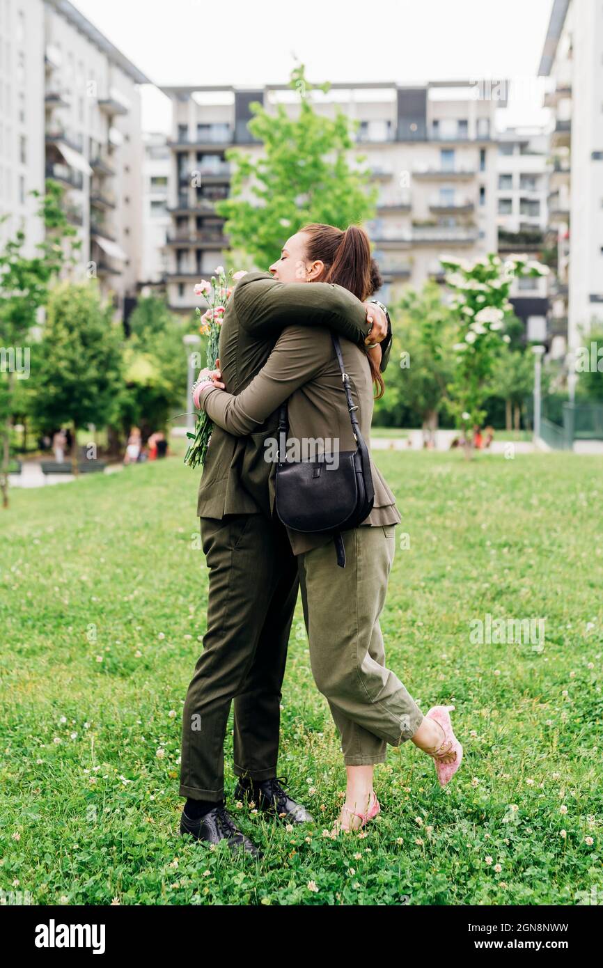 Business couple hugging each other while standing at park Stock Photo ...