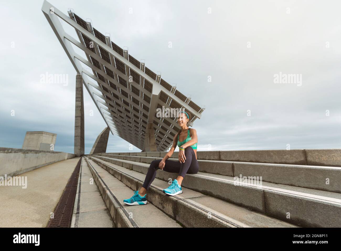 Sportswoman resting while sitting on steps Stock Photo - Alamy