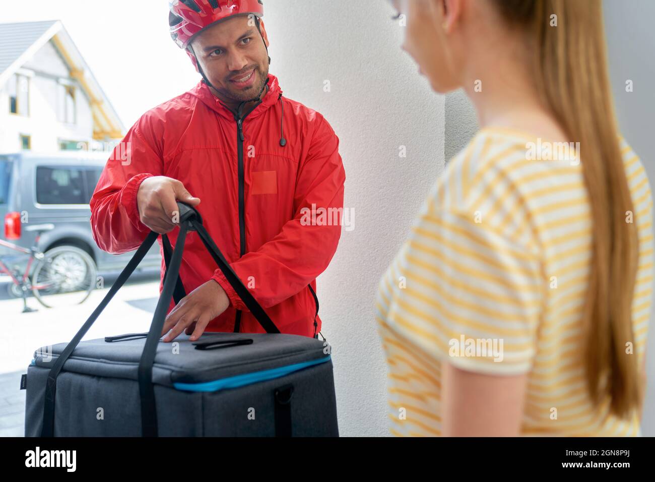 Male delivery person delivering pizza to female customer at home ...