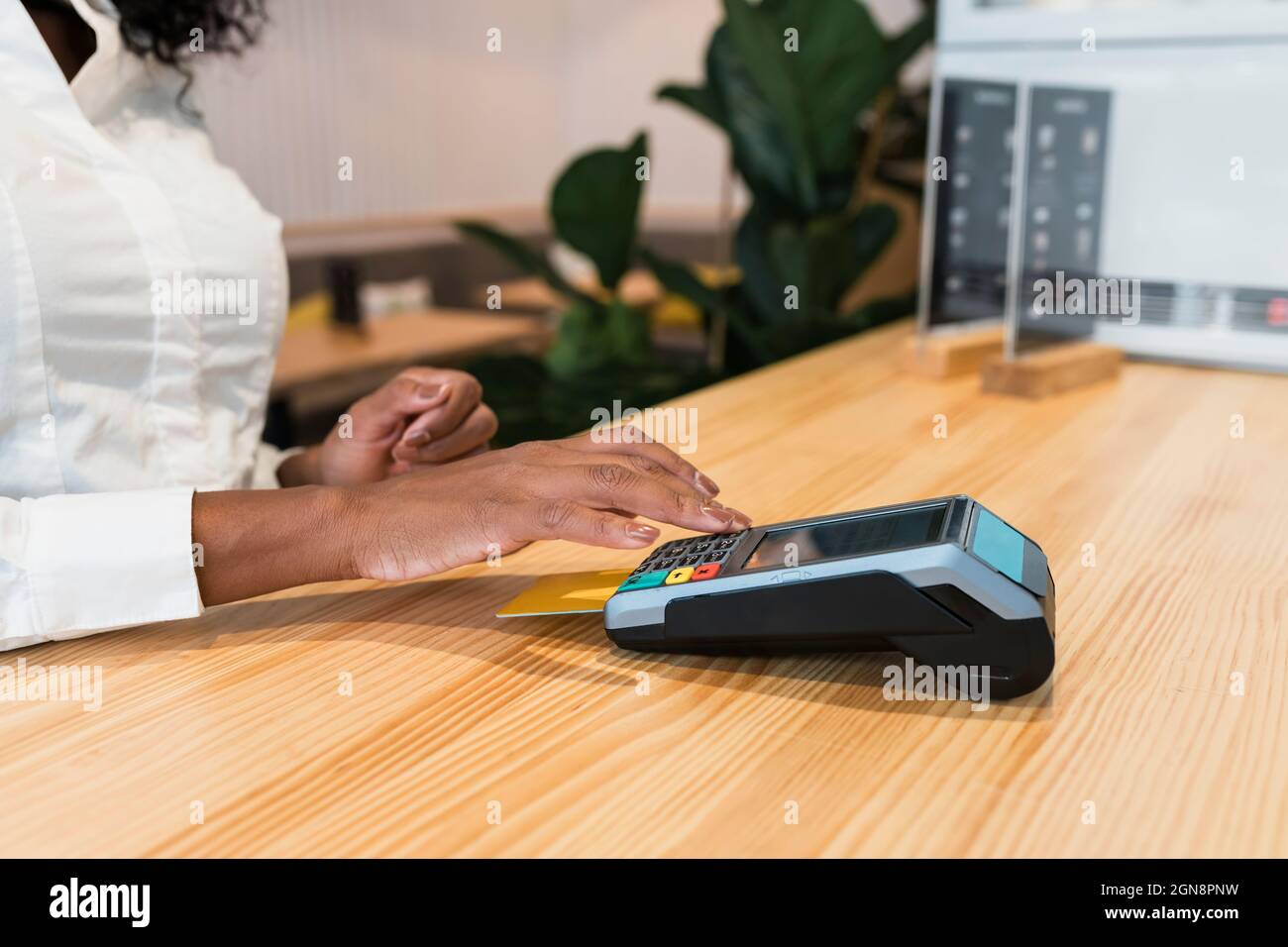 Young businesswoman making payment through credit card at coffee shop ...