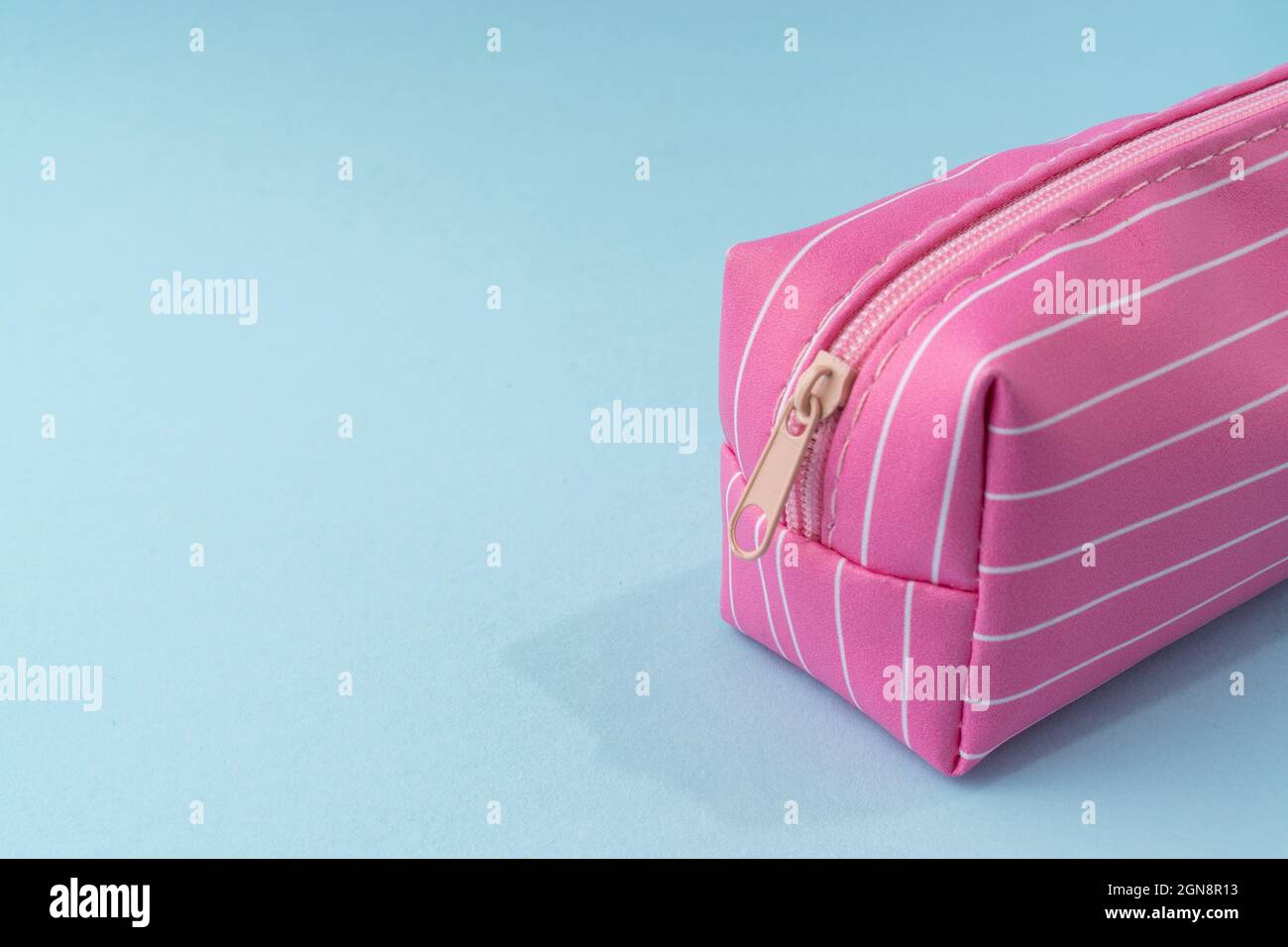 Pink color pencil box on light blue background Stock Photo - Alamy
