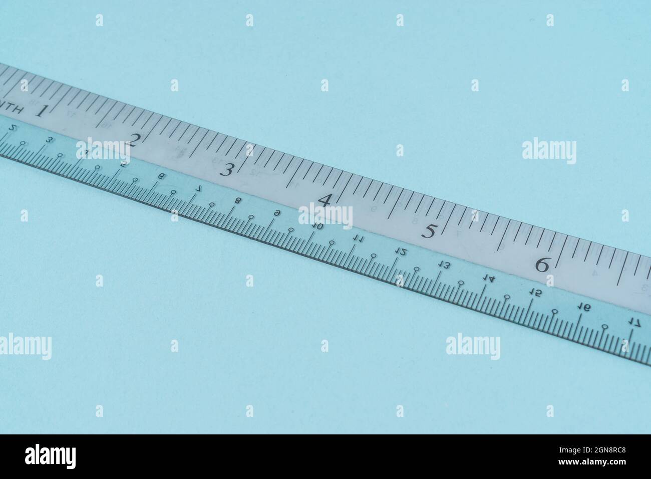 Plastic ruler on light blue background Stock Photo - Alamy