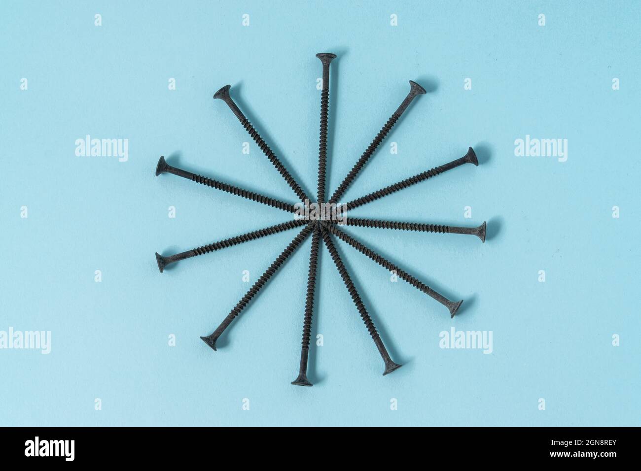 Screw on light blue background Stock Photo - Alamy