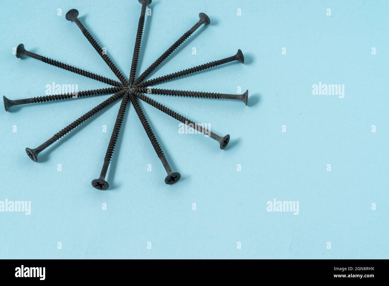 Screw on light blue background Stock Photo - Alamy