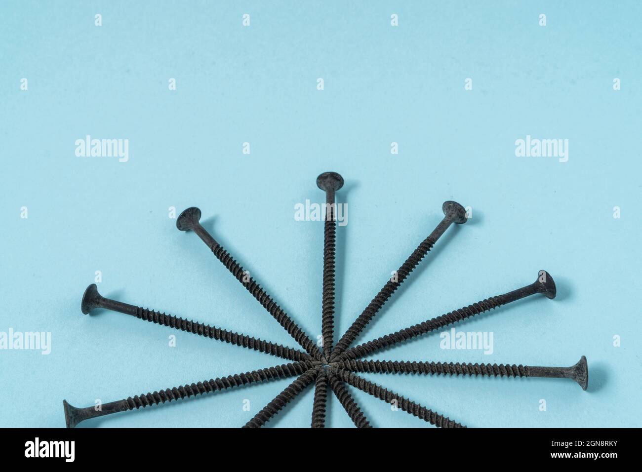 Screw on light blue background Stock Photo - Alamy