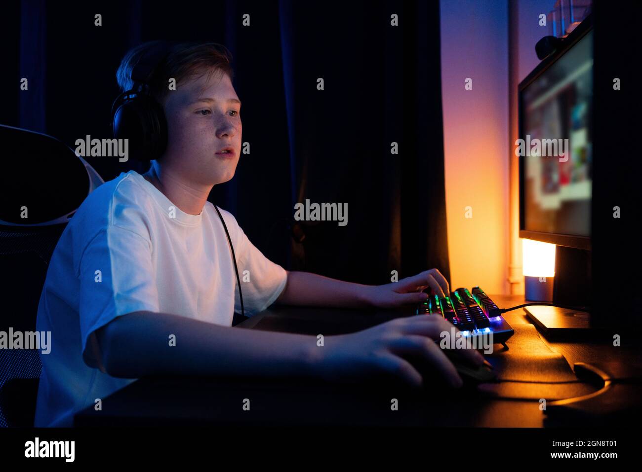 Boy playing game on computer at home Stock Photo - Alamy