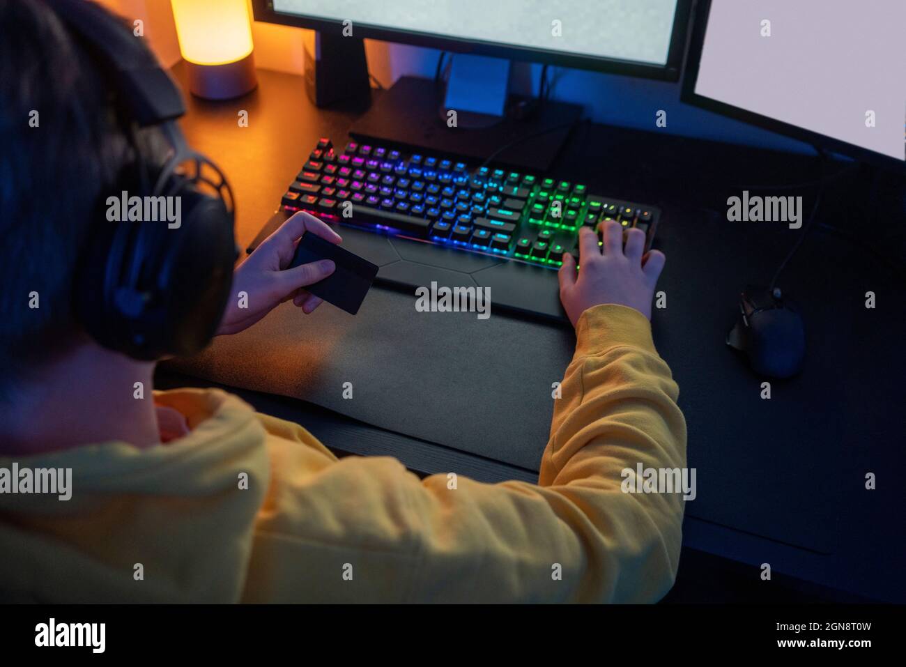 Boy holding credit card while playing video game at home Stock Photo ...