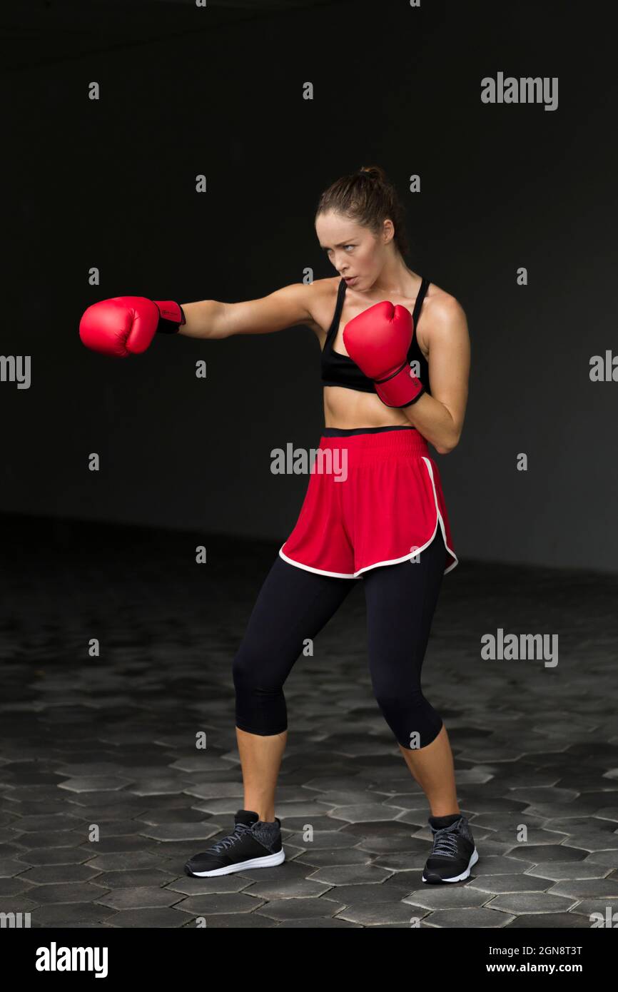 Sportswoman practicing boxing at basement Stock Photo - Alamy
