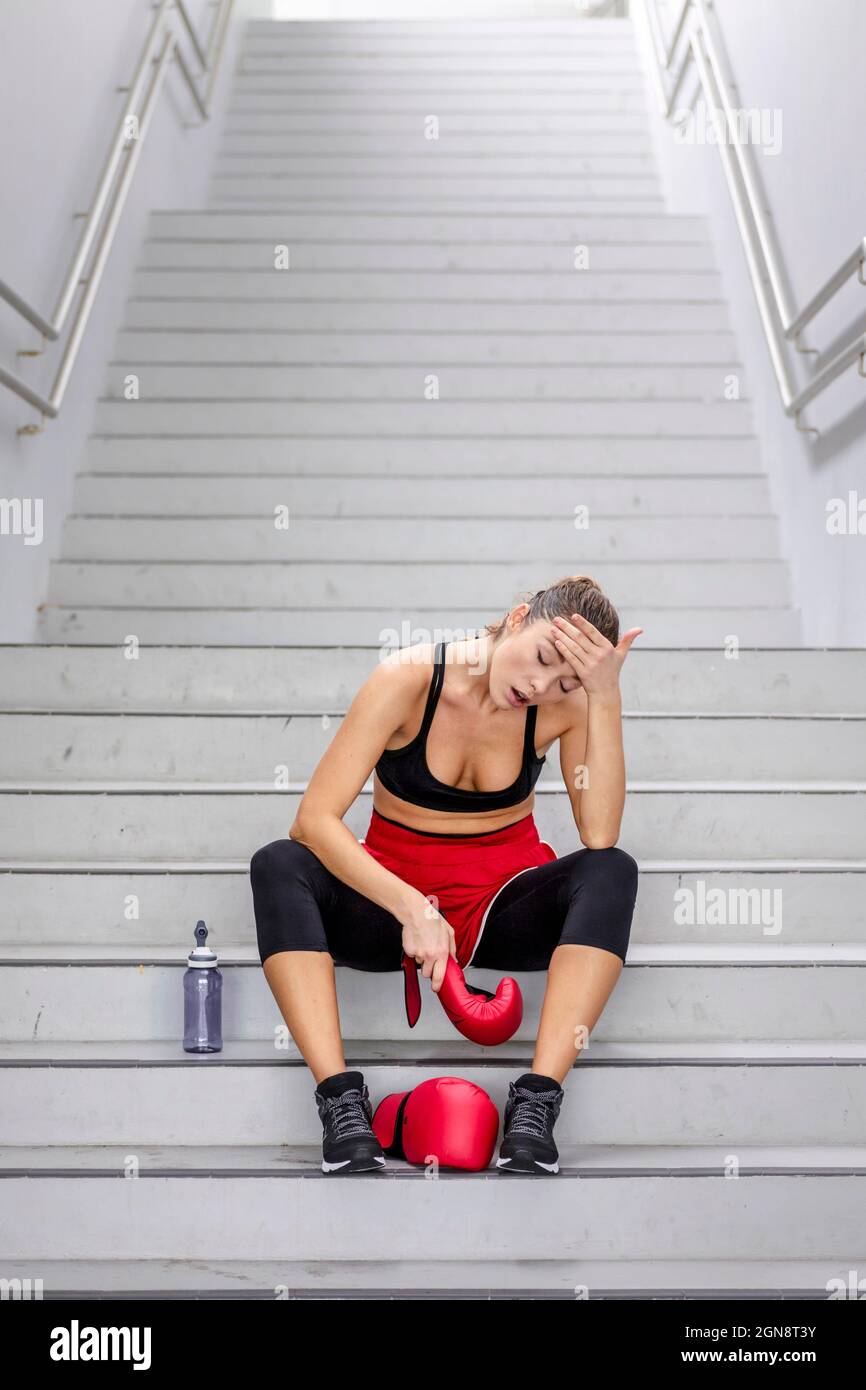 Tired female boxer sitting on steps Stock Photo - Alamy