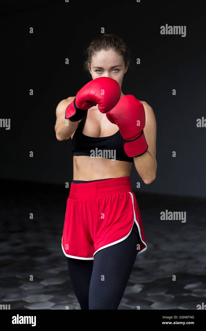 Female boxer practicing during sports training at basement Stock Photo ...