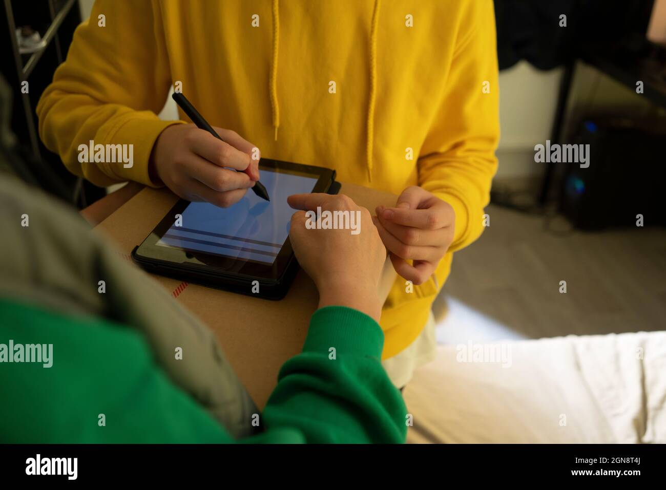 Boy signing reception of package with digitized pen Stock Photo - Alamy