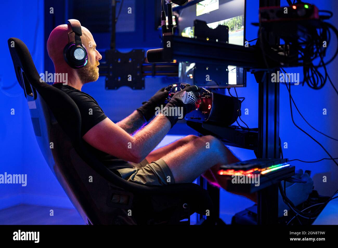 Male gamer wearing headphones while playing video game at studio Stock ...