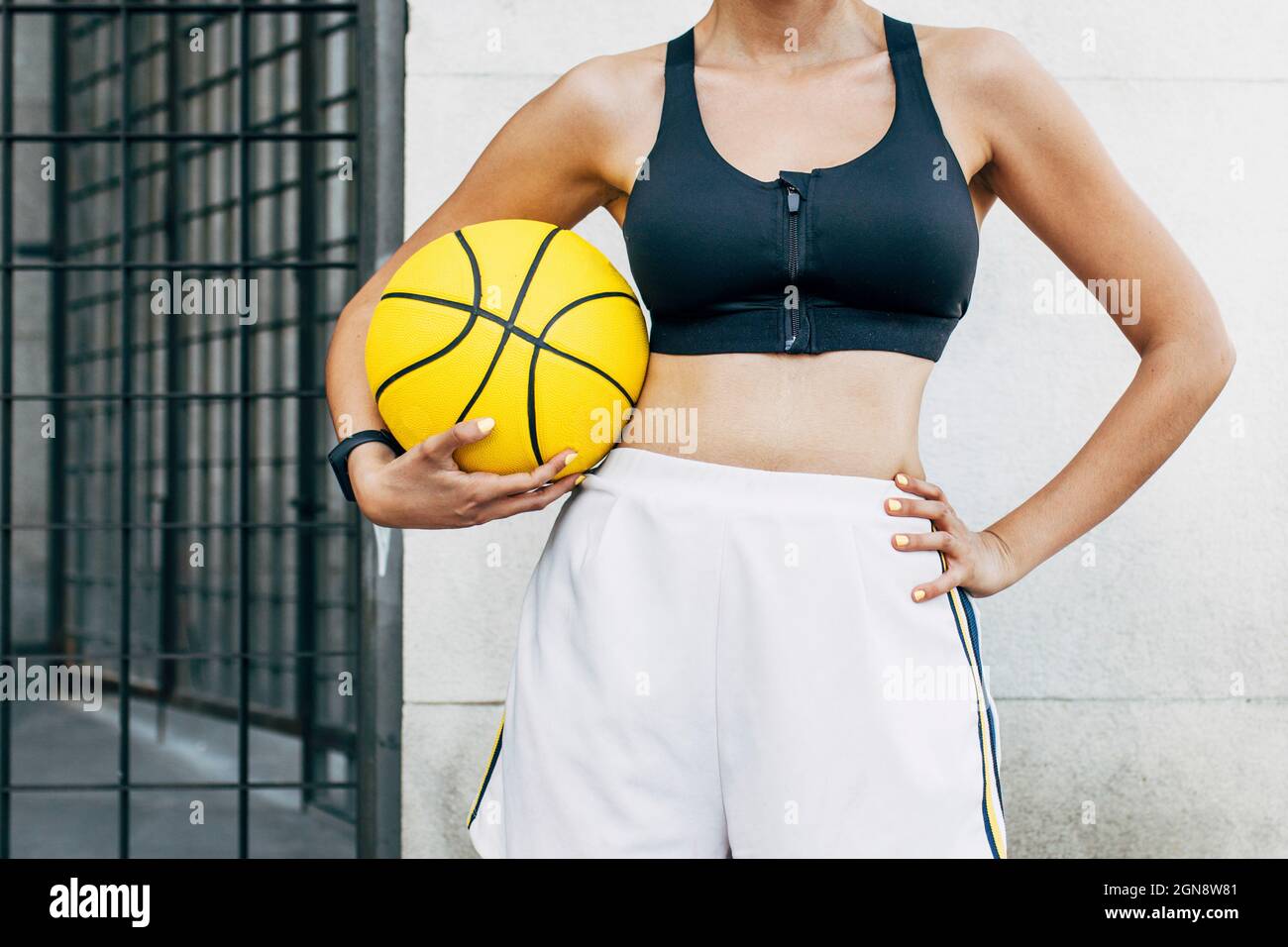 Basketball player with sports ball and hand on hip Stock Photo - Alamy