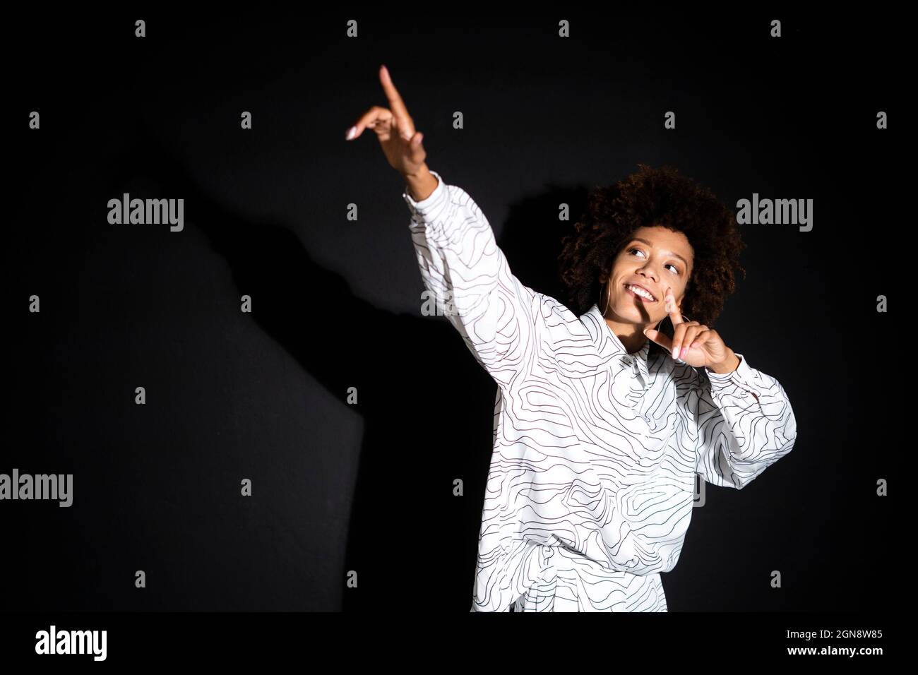 Female fashion model dancing against black background Stock Photo - Alamy