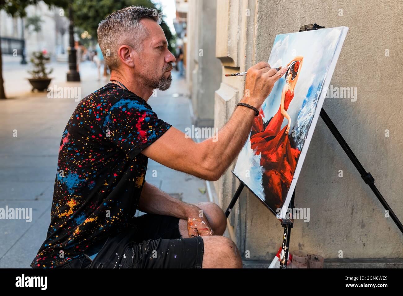 Mature male painter painting female on canvas Stock Photo - Alamy