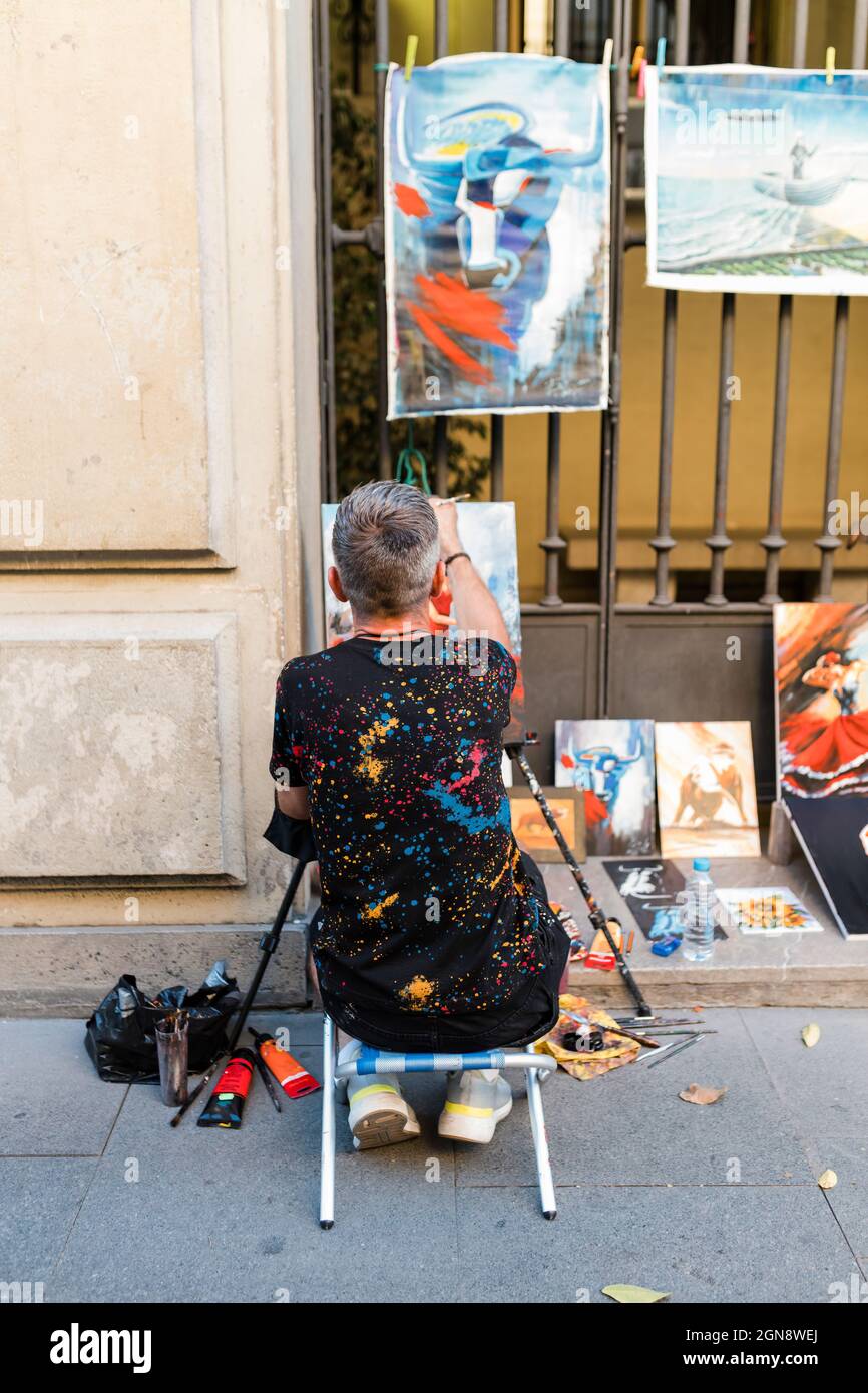 Male street artist painting on footpath Stock Photo - Alamy