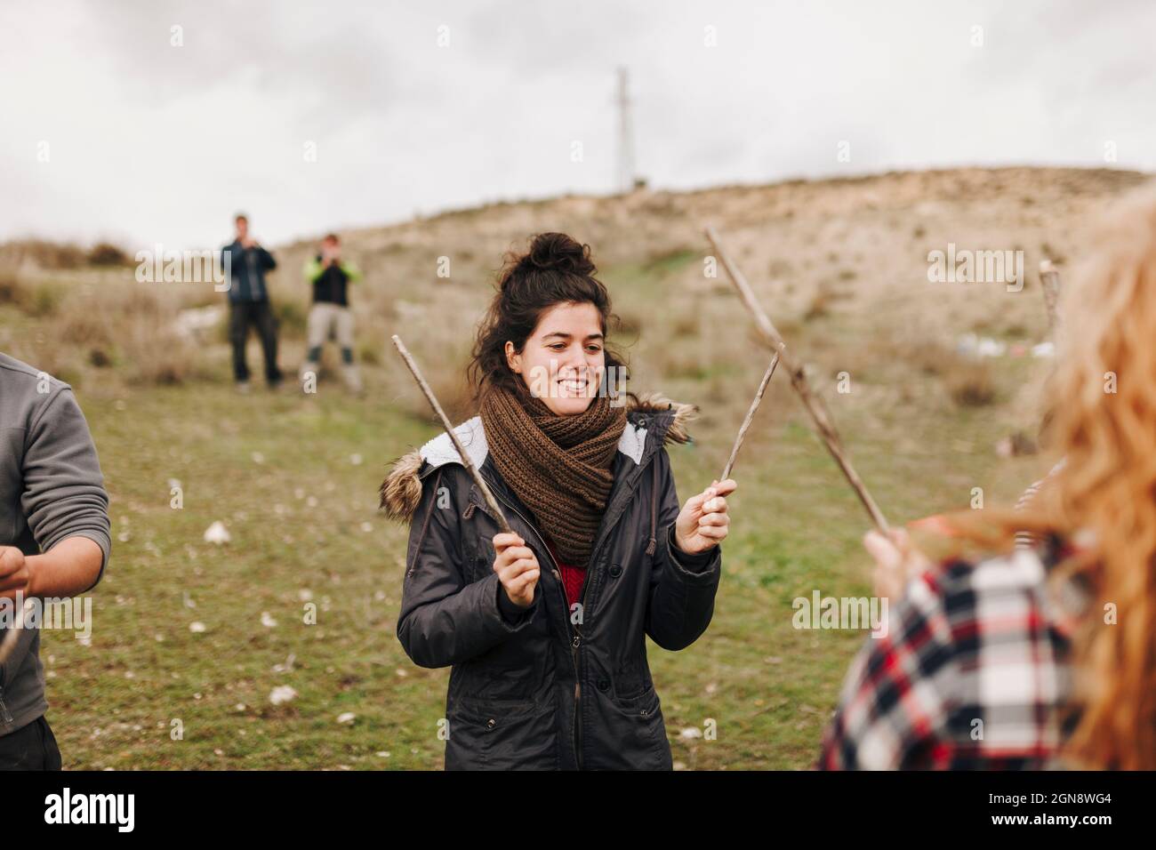 Female friends dancing together with sticks in field Stock Photo - Alamy