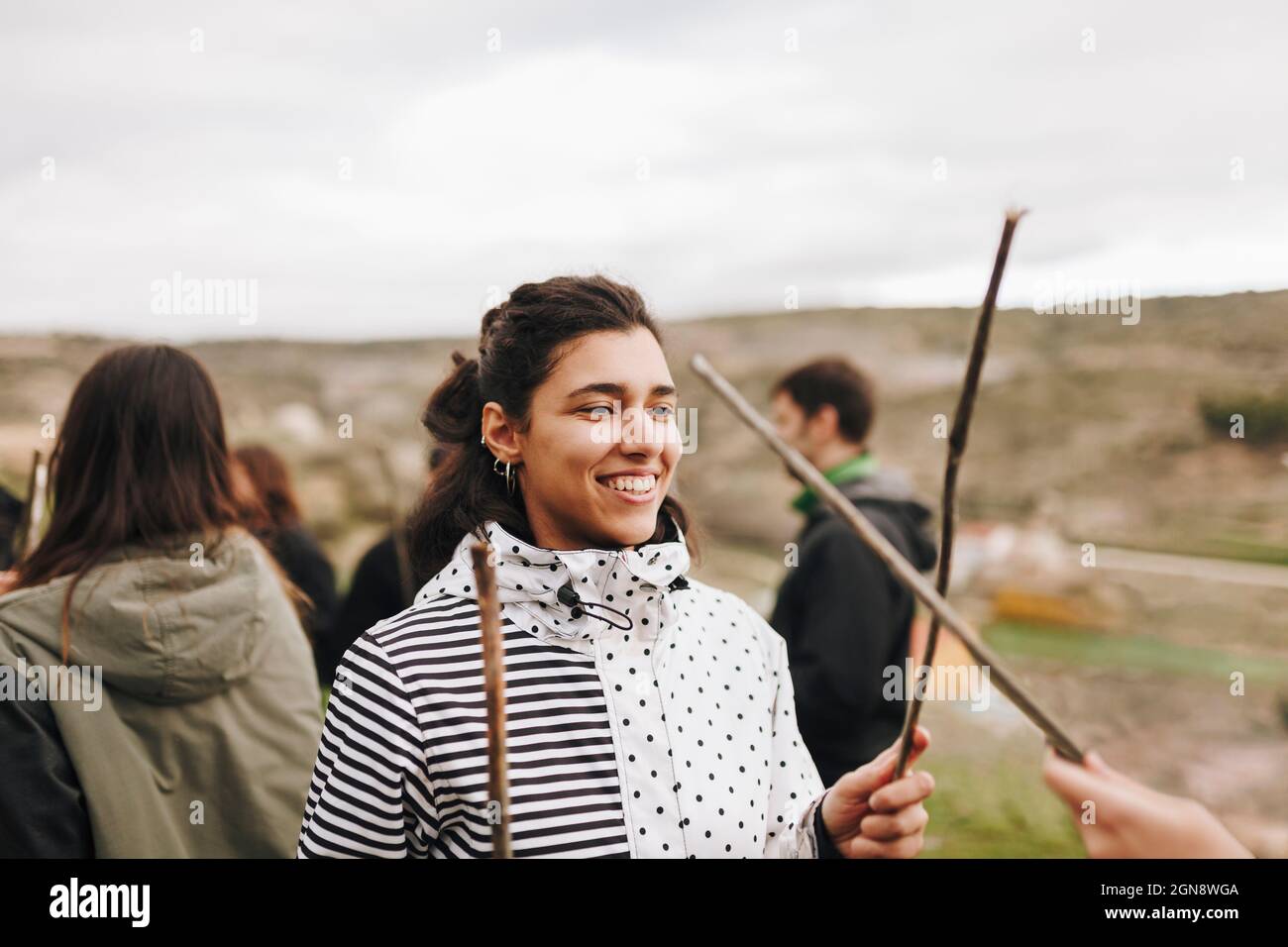 Smiling young woman dancing with sticks Stock Photo - Alamy