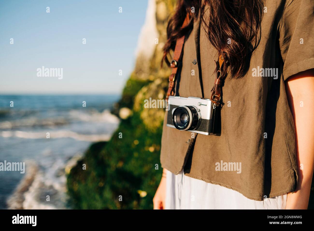 Young woman with camera standing at beach Stock Photo - Alamy