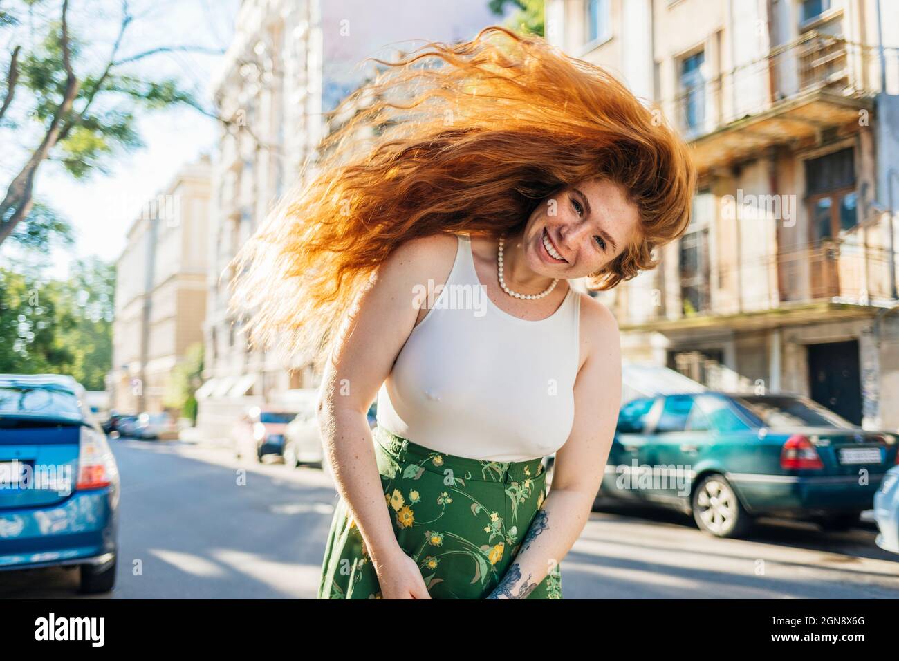 Cheerful young woman tossing hair Stock Photo - Alamy