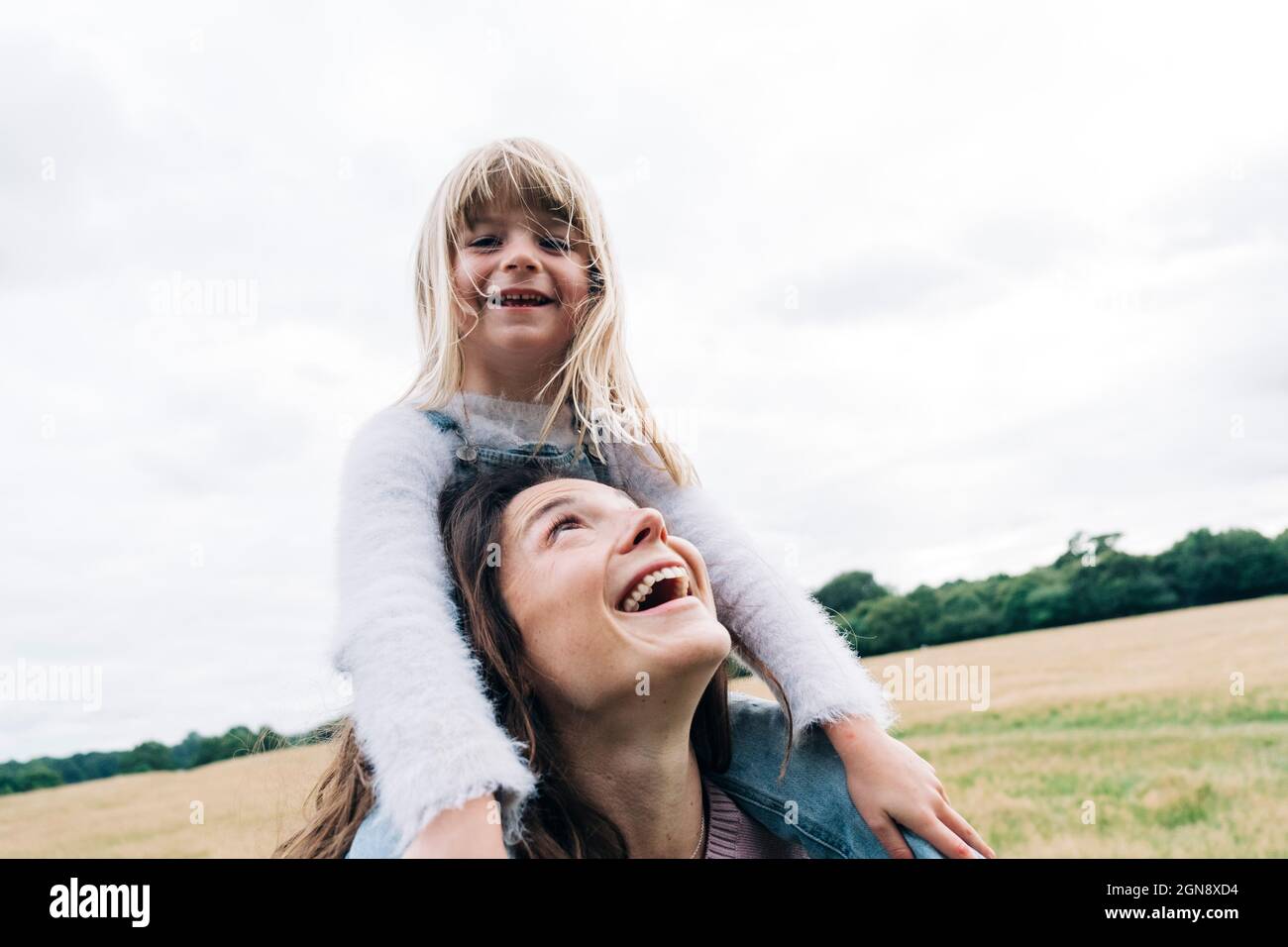 Playful woman carrying girl while playing Stock Photo - Alamy