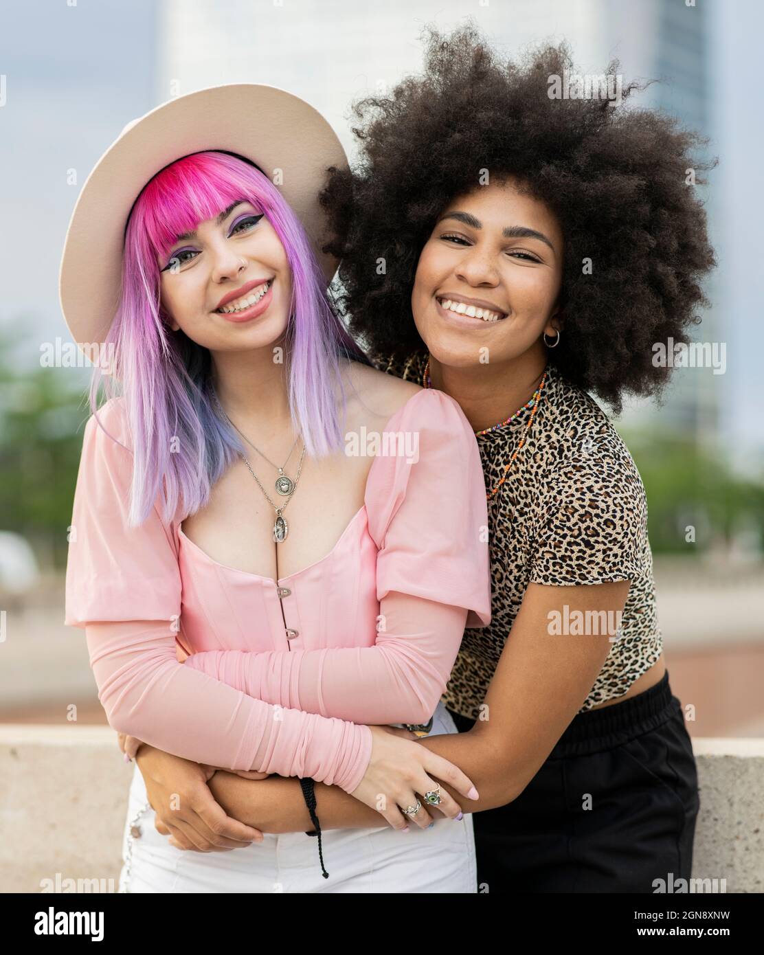 Happy young Afro woman embracing hipster female friend Stock Photo - Alamy