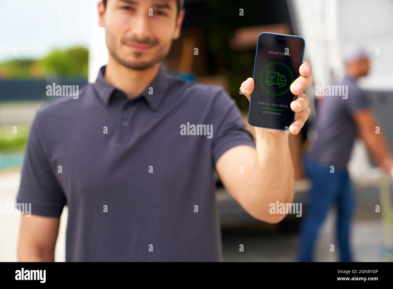 Delivery man showing mobile app on smart phone Stock Photo - Alamy