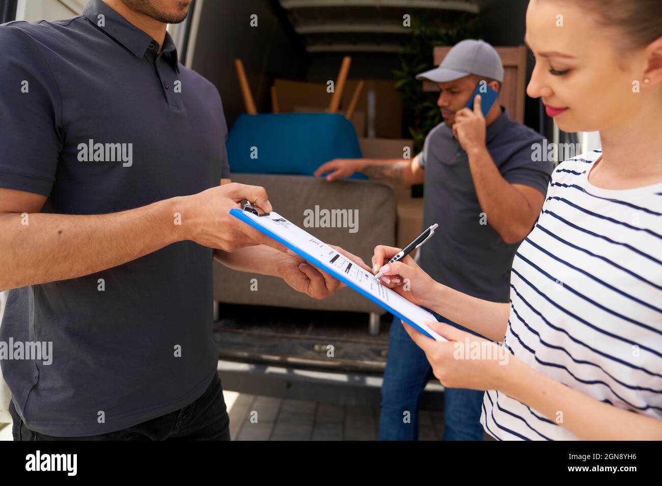 Delivery man taking signature of woman on documents Stock Photo - Alamy
