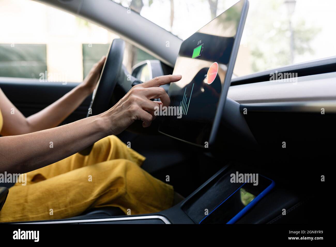 Woman using digital tablet while driving electric car Stock Photo - Alamy