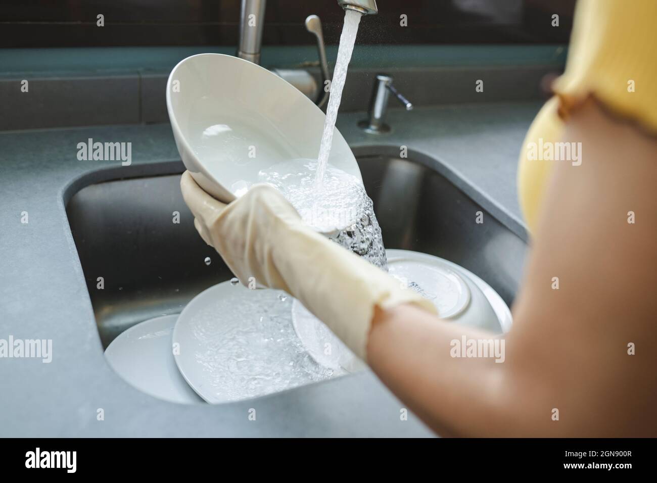 Mature woman washing utensils in kitchen sink at home Stock Photo - Alamy